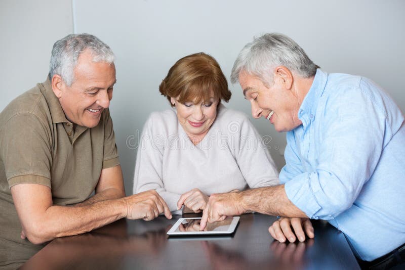 Senior Classmates Watching Man Using Digital Tablet at Desk Stock Image ...