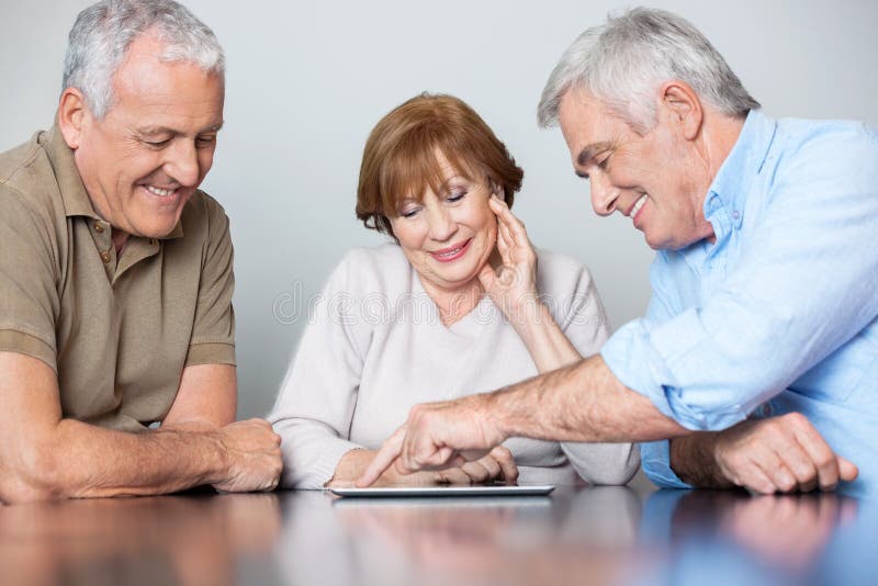 Senior Classmates Watching Man Using Tablet PC at Desk Stock Image ...