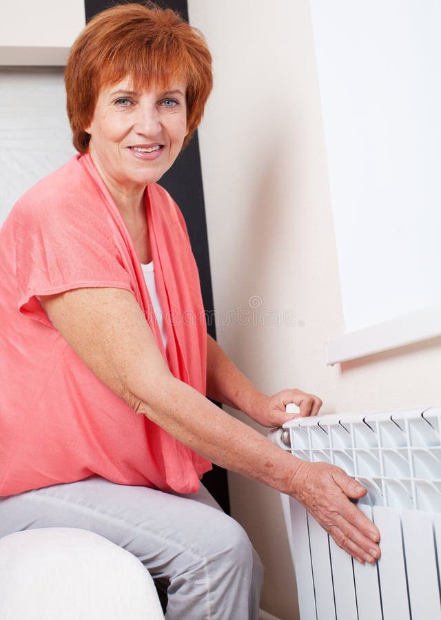 Smiling Woman Adjusting Thermostat on Home Heating System Stock Image ...