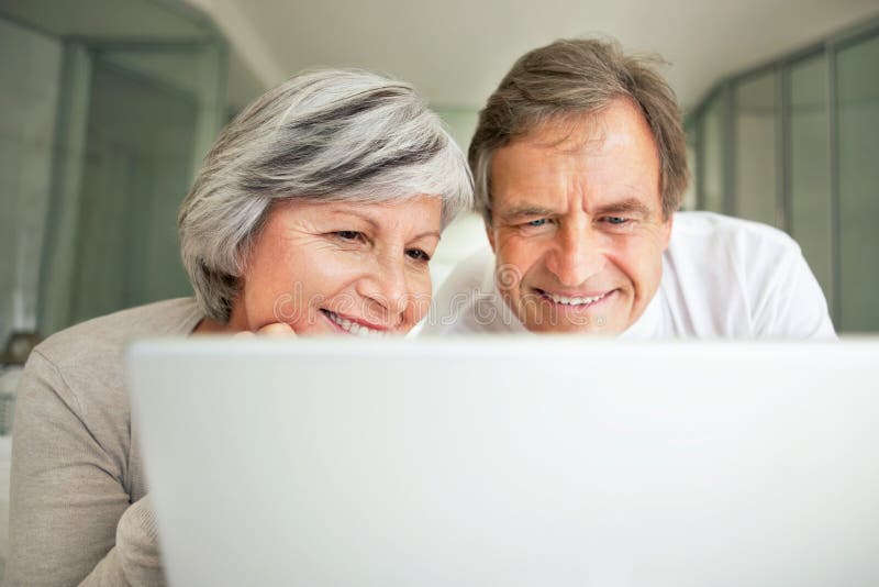 Senior Couple Browsing the Internet while on Bed Stock Image - Image of ...
