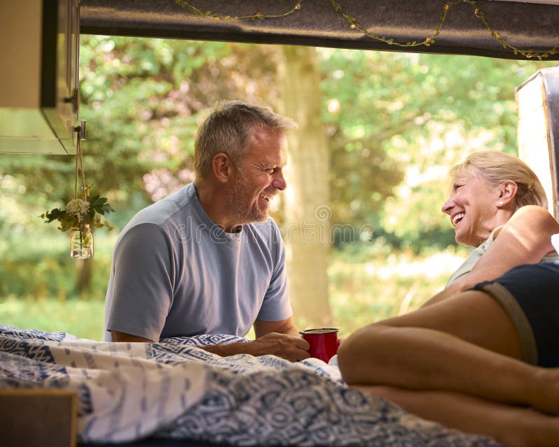 Senior Couple Camping in Countryside Relaxing Drinking Coffee Inside RV ...