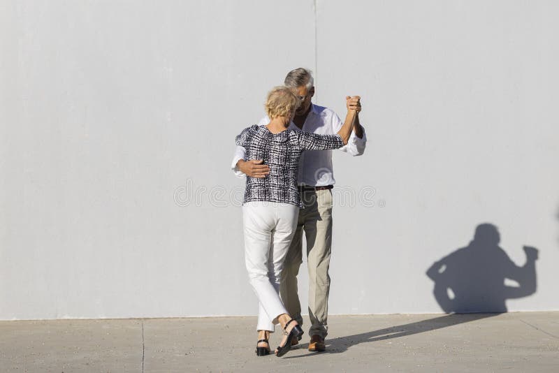 Senior Couple Dancing Tango in Front of White Wall Stock Image - Image ...