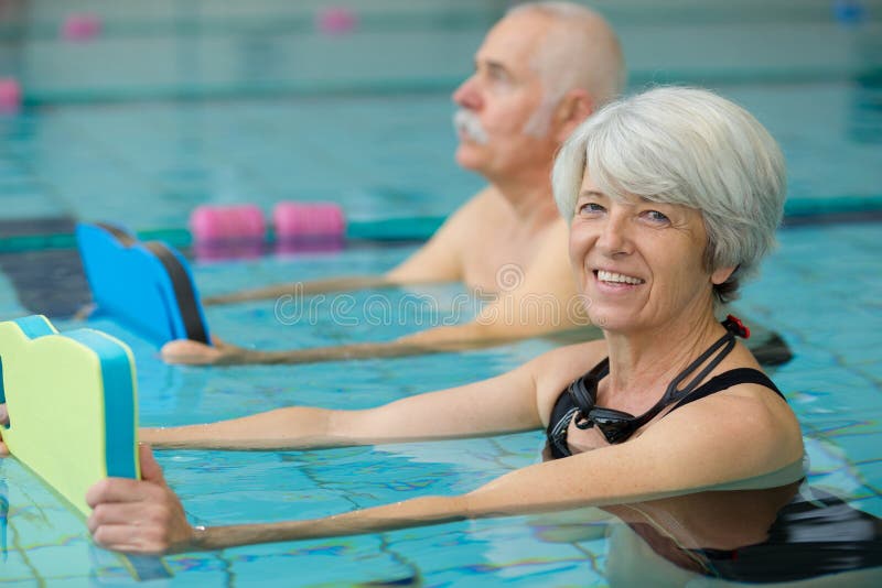 Senior Couple Doing Exercise in Swimming Pool Stock Photo - Image of ...