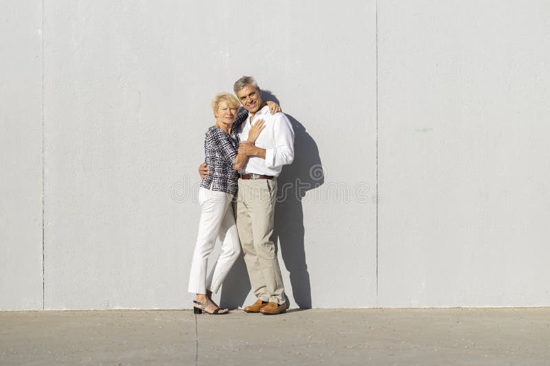 Senior Couple Embracing and Smiling at a Wall Outdoors Stock Image ...