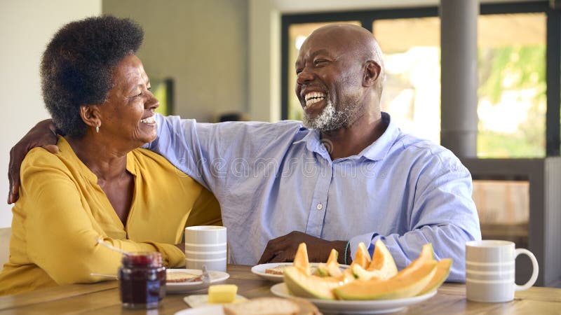 Senior Couple at Home Enjoying Breakfast Around Table Together Stock ...