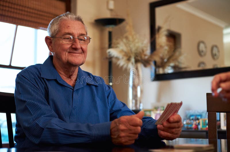 Senior Couple at Home Sitting at Table Playing Cards Together Stock ...