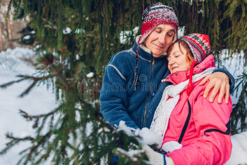 Senior Couple Hugging In Winter Forest Man And Woman Walking Outdoors