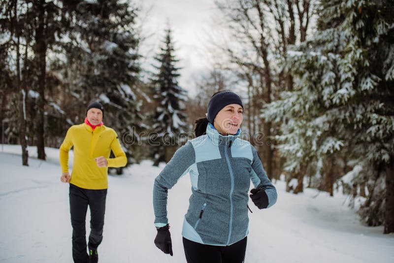 Senior Couple Jogging Together in Winter Forest. Stock Photo - Image of ...
