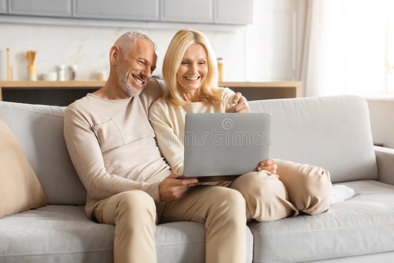Senior Couple Laughing while Using a Laptop Stock Photo - Image of ...