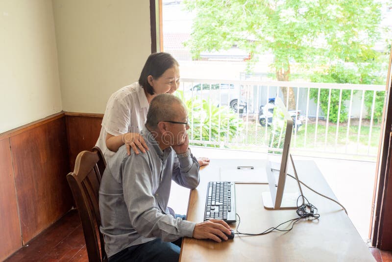 Senior Couple Looking at Desktop Computer at Desk Stock Photo - Image ...