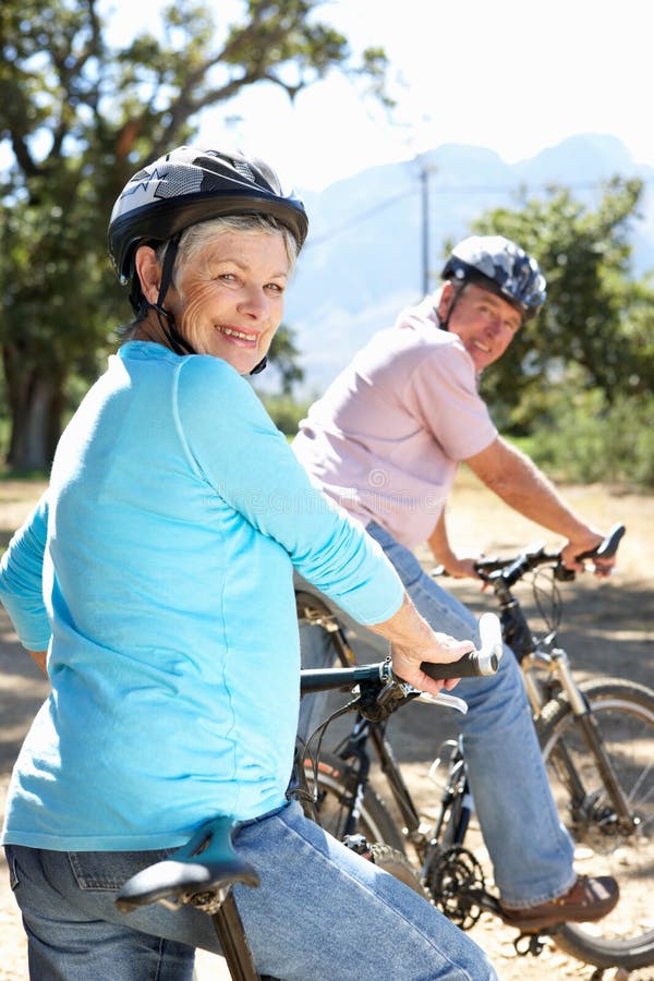 Senior Couple Riding Bikes Having Fun Stock Photo - Image of retirement ...