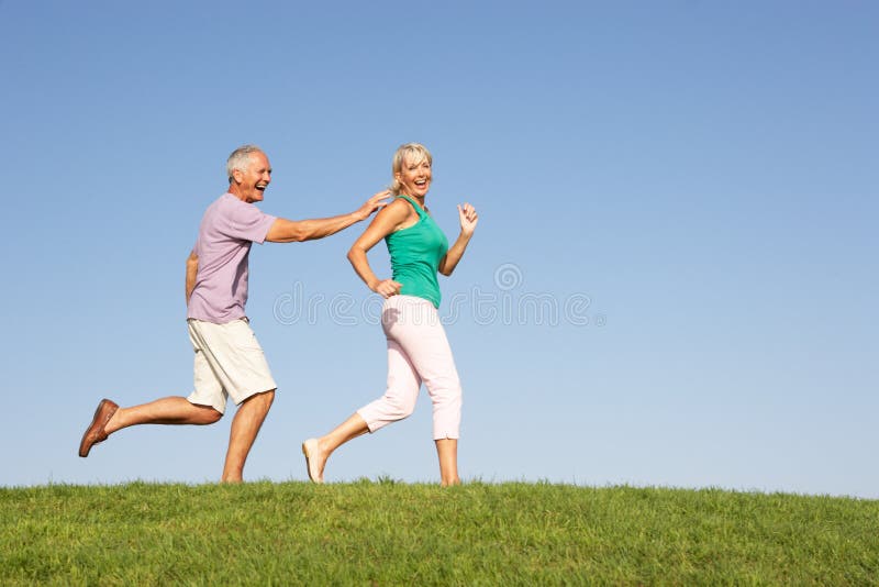 Senior Couple Running Though Field Stock Photo - Image of playing ...