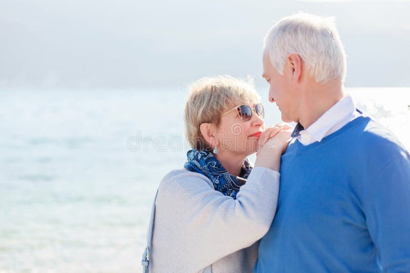 Senior Couple At Sea Beach Outdoor Happy Man And Woman Are Hugging
