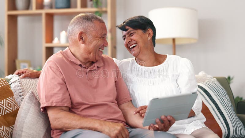 Senior Couple Tablet And Laugh Or Relaxing At Home Humor And Bonding