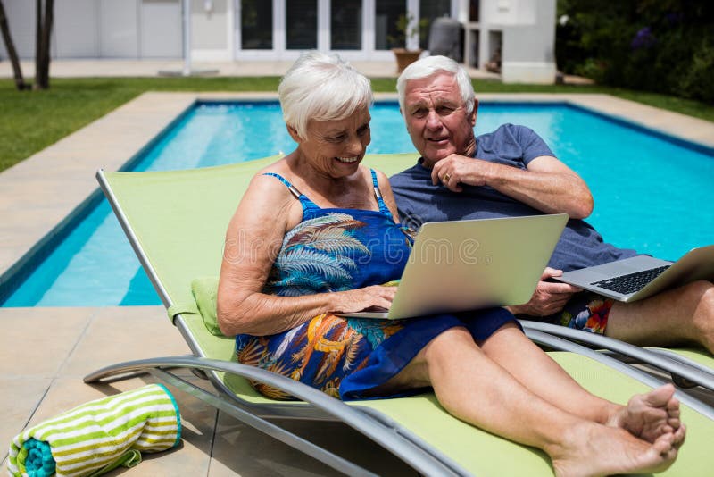 Senior Couple Using Laptop on Lounge Chair Stock Photo - Image of ...