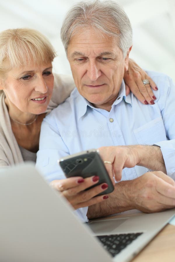 Senior Couple Using Smartphone Stock Image - Image of filling, website ...