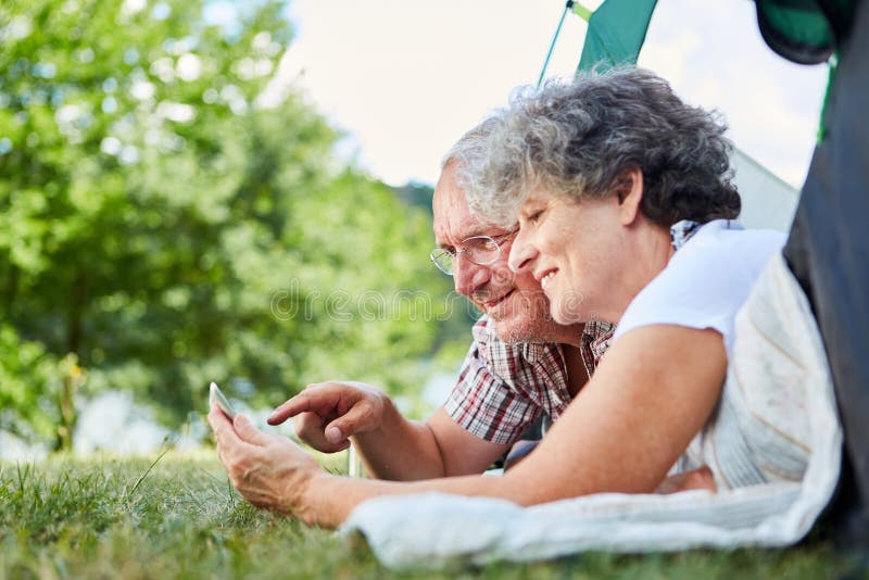 Senior Couple Using Tablet while Camping Stock Image - Image of ...