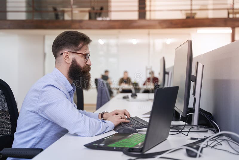 Software Developer Working on Computer in it Office, Sitting at Desk ...