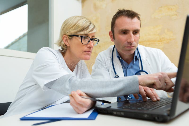 Senior Doctor with Female Assistant Working on Medical Documents Stock ...