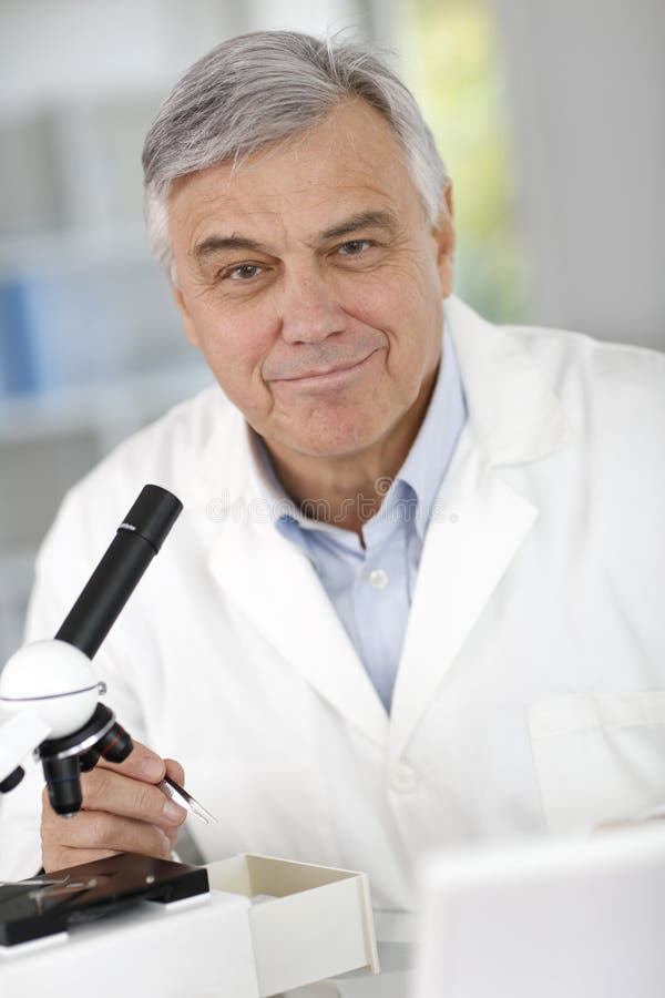 Doctor in Laboratory Checking Samples through Microscope Stock Image ...