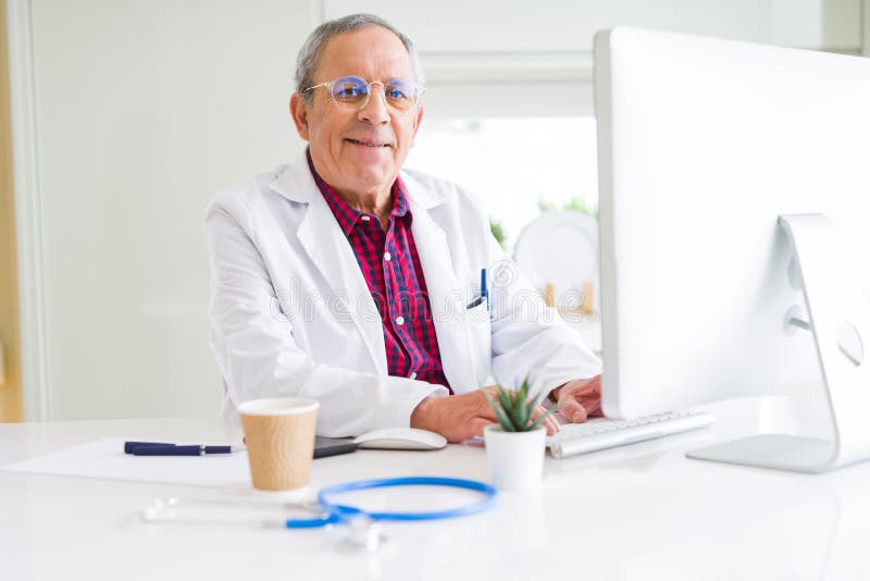 Senior Doctor Man at the Clinic Working with Computer and Smiling Stock ...