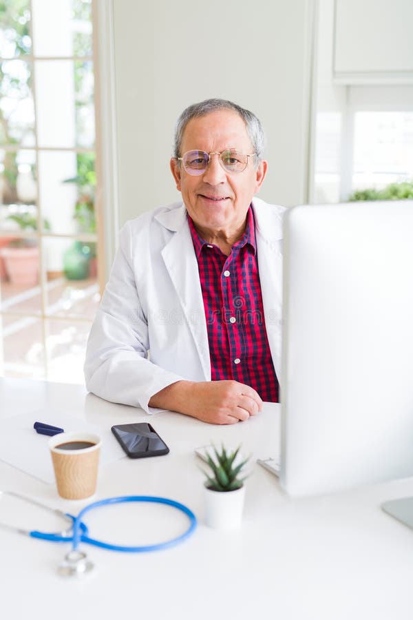 Senior Doctor Man at the Clinic Working with Computer and Smiling Stock ...