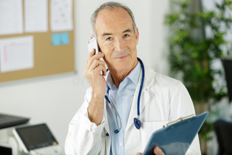 Senior doctor on phone stock image. Image of doctor - 202016131