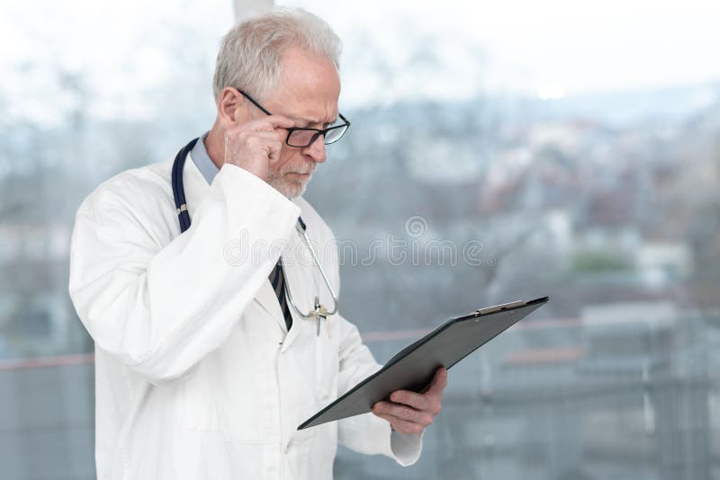 Senior Doctor Reading Notes on Clipboard Stock Image - Image of ...