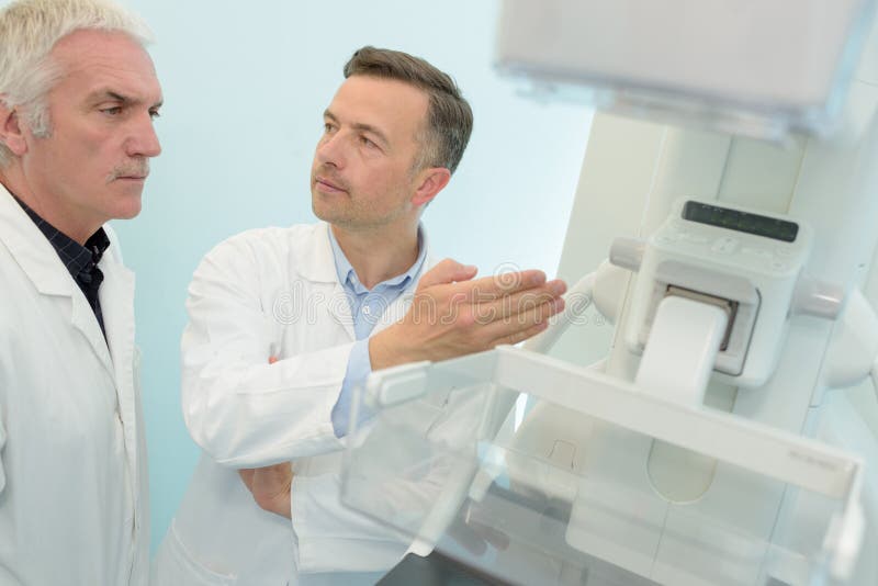 Senior Doctors Discussing Next To Machine in Hospital Stock Image ...