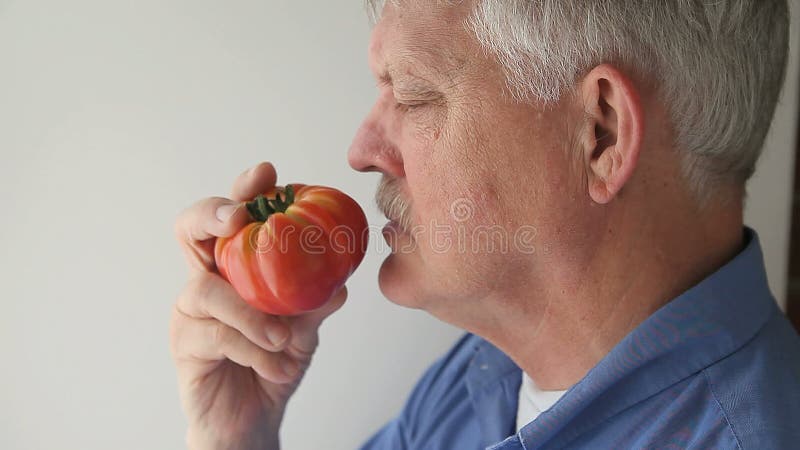Senior eats tomato stock video. Video of hand, nourishment - 36019114