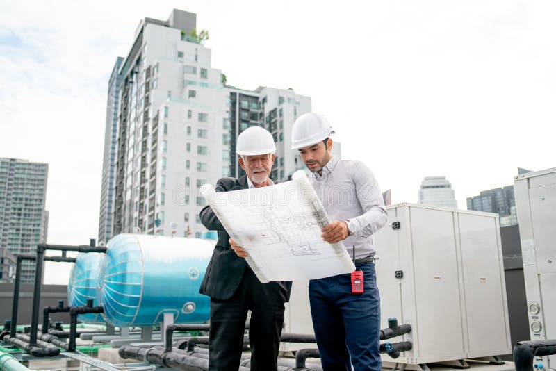 Senior Engineer and Young Worker Shake Hands and Look at Camera and ...