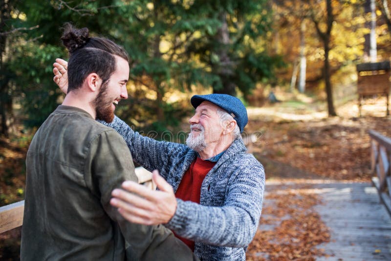 Senior Father And His Son On Walk In Nature Hugging And Talking Stock