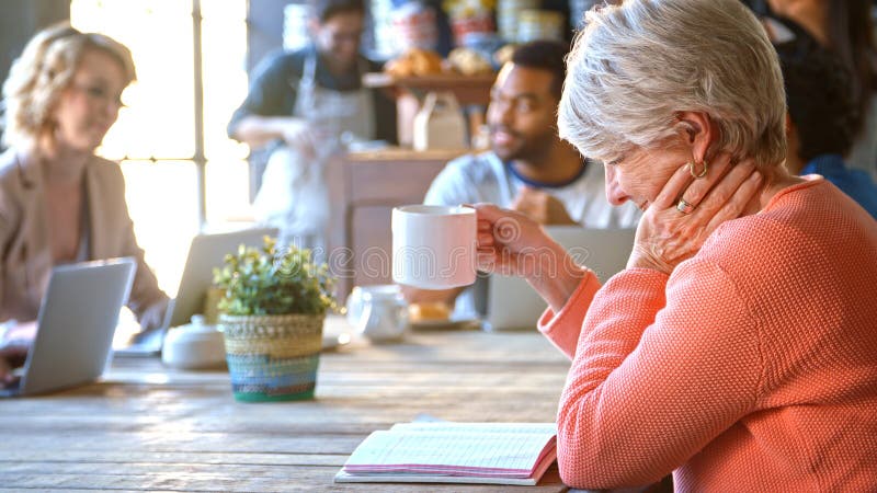 Senior Female Customer in Coffee Shop Sitting at Table with Drink ...