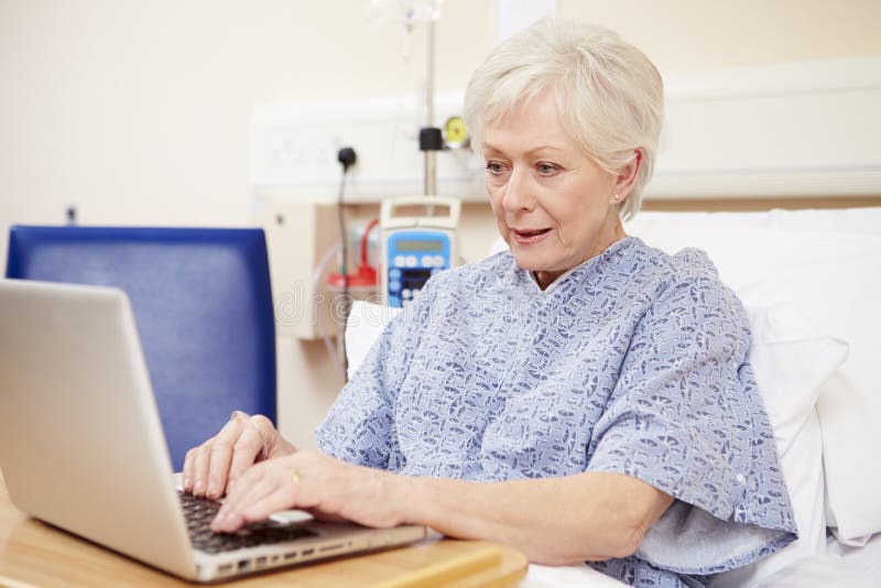 Senior Female Patient Using Laptop in Hospital Bed Stock Photo - Image ...