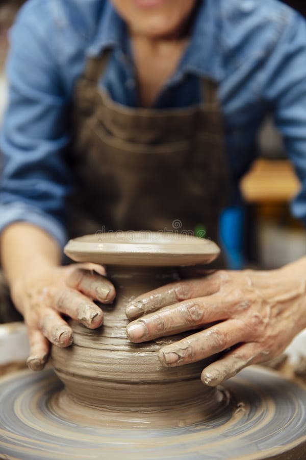Senior Female Potter Working on Pottery Wheel while Sitting in Her ...