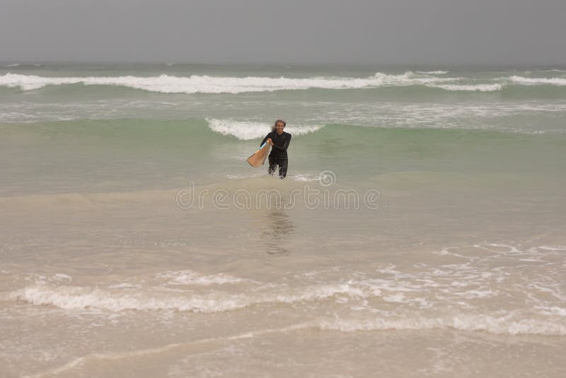 Senior Female Surfer with Surfboard Walking in the Sea Stock Image ...