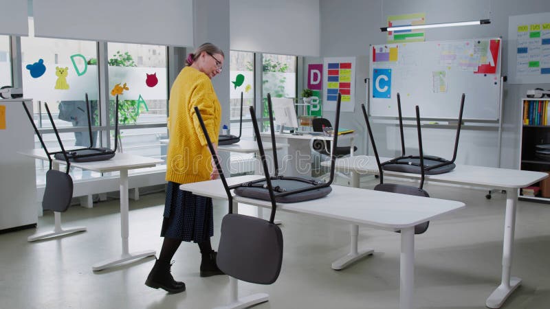 Senior Female Teacher Walking in Empty Class Waiting for Students Stock ...