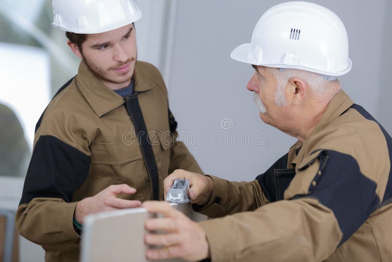 Senior Foreman Sharing Ideas with Young Builder Stock Photo - Image of ...