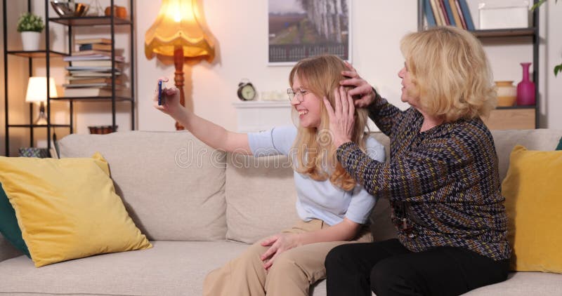 Grandmother Using Cell Phone And Having Fun With Her Granddaughter