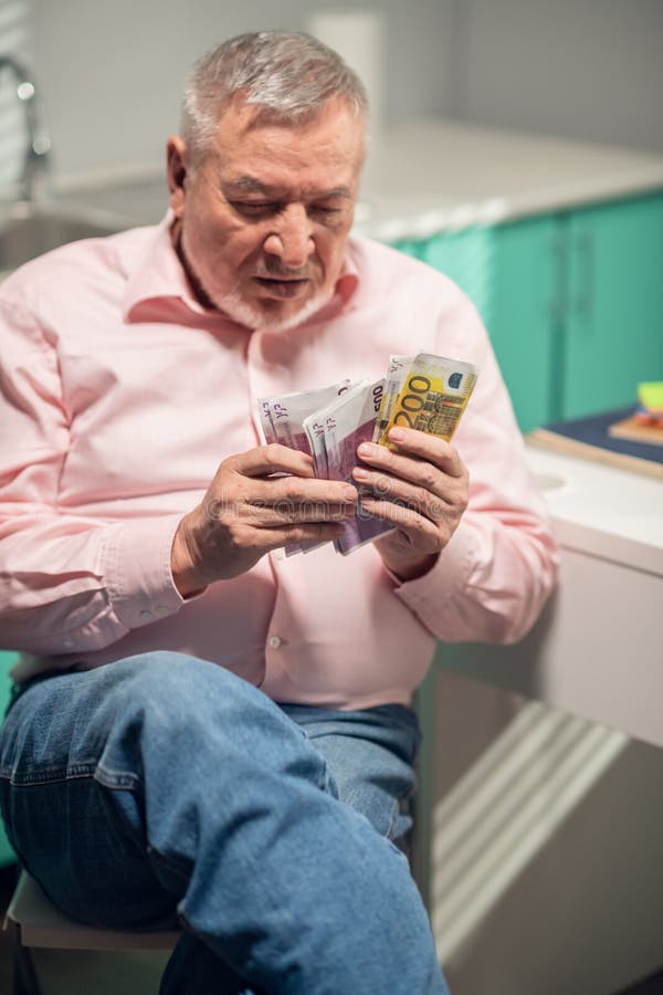 Senior Grey-haired Man Counting Money, Euro Bills, in the Kitchen Stock ...