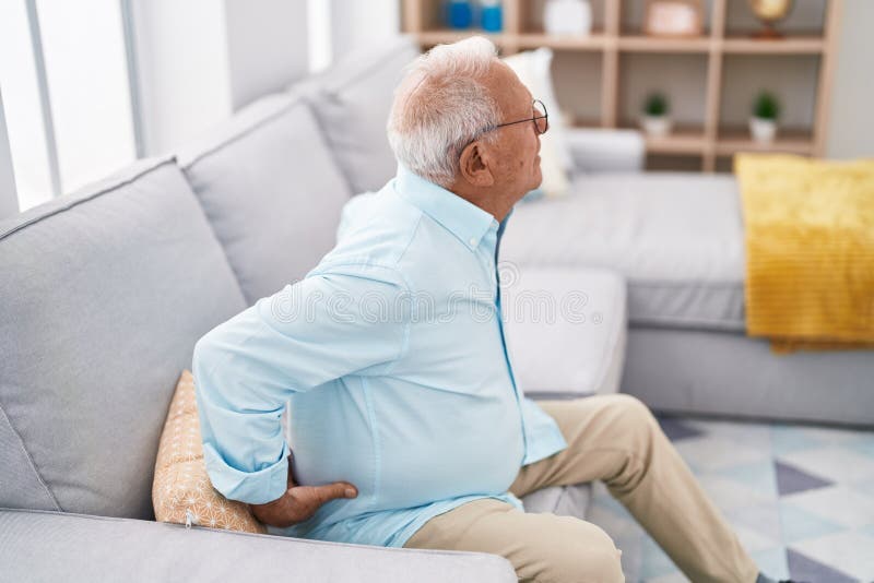 Senior Grey-haired Man Suffering for Backache Sitting on Sofa at Home ...