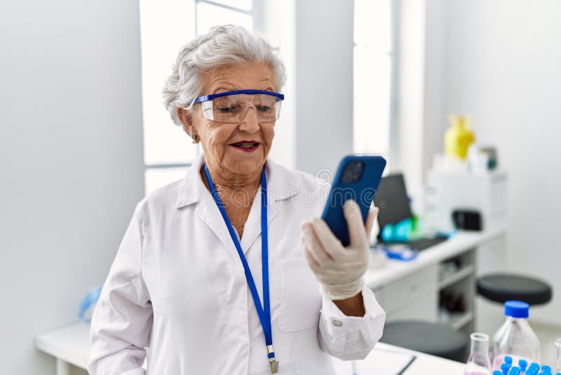 Senior Grey-haired Woman Wearing Scientist Uniform Using Smartphone at ...
