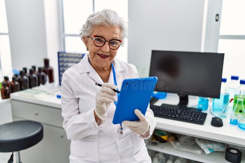 Senior Grey-haired Woman Wearing Scientist Uniform Using Touchpad at ...
