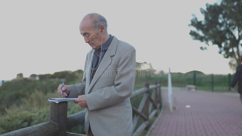 Elderly Journalist Taking Notes in a Park Stock Video - Video of profession, experience: 384229787