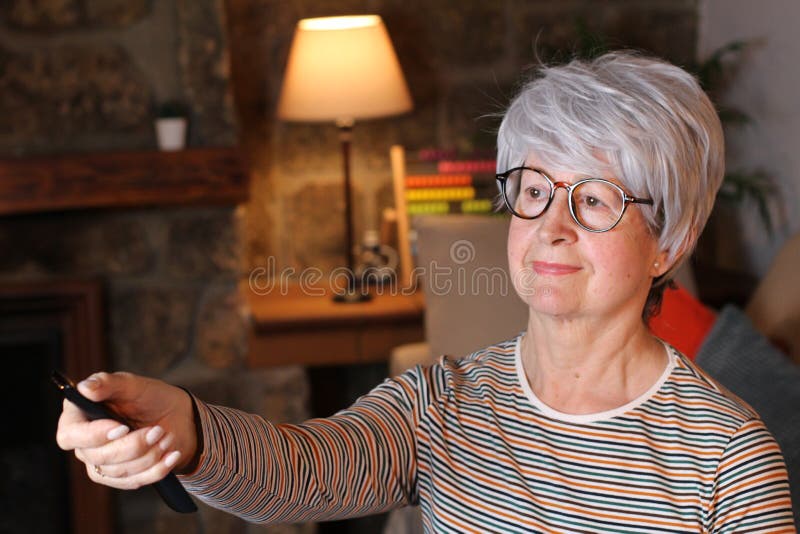 Senior Lady Using Remote Control Stock Photo - Image of beautiful, grey ...