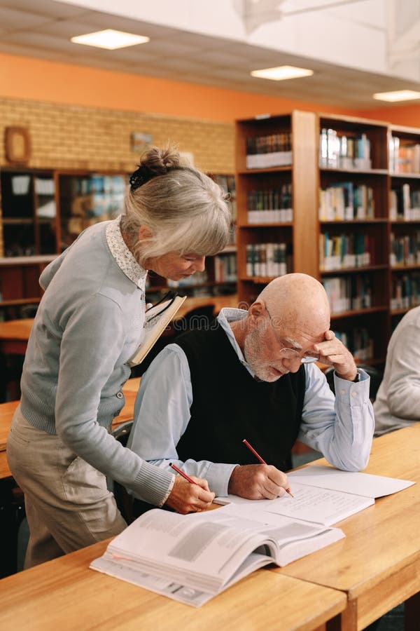Senior Lecturer Helping an Elderly Man in University Class Stock Photo ...