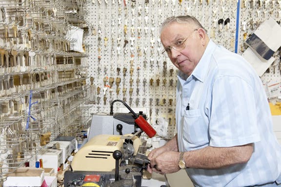 Senior Locksmith Looking Away while Making Key in Store Stock Image ...