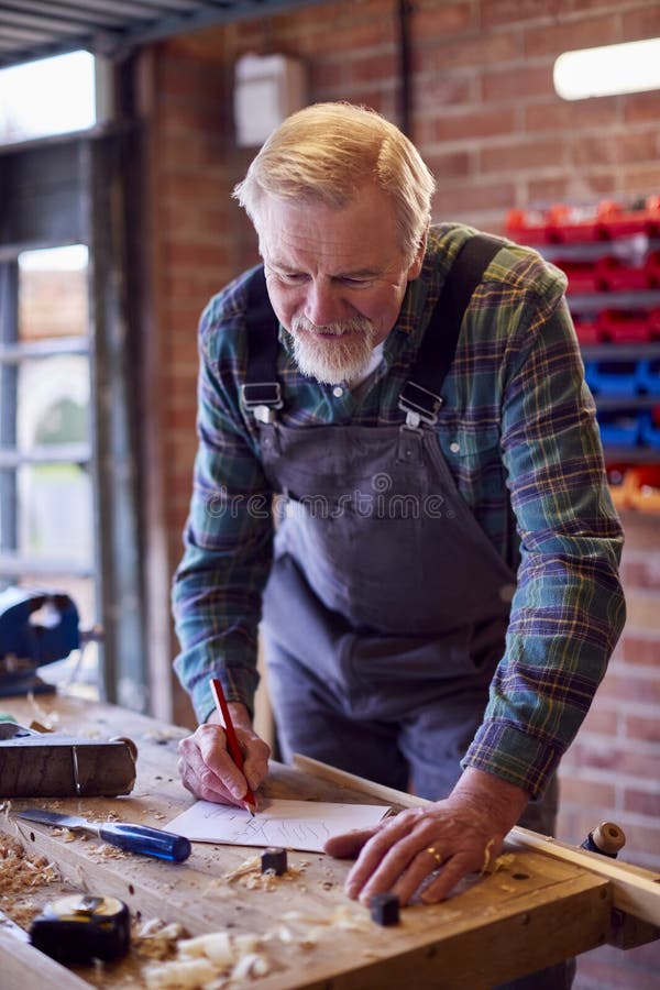 Senior Male Carpenter in Garage Workshop Sketching Out Design on Paper ...