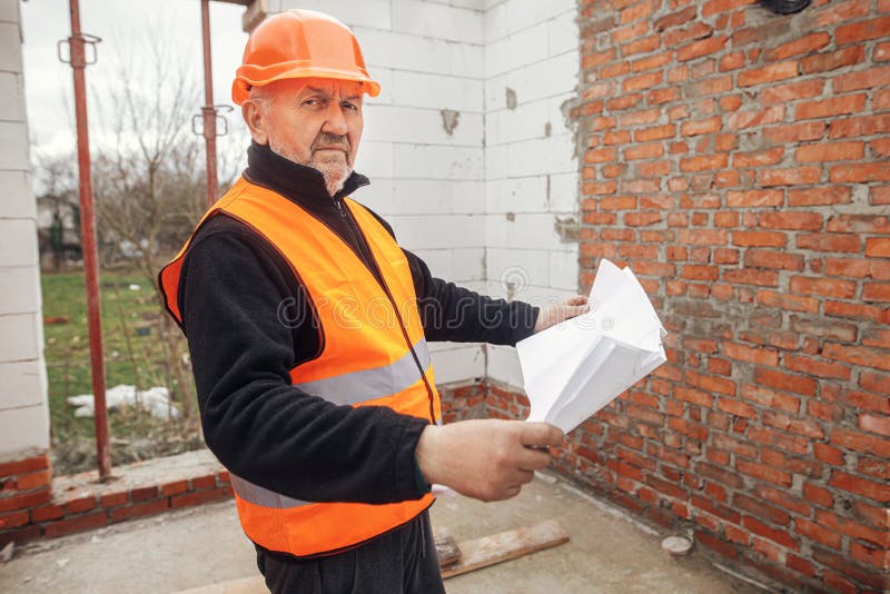 Senior Male Foreman in Hardhat Checking Blueprints of Building New ... Senior Male Foreman in Hardhat Checking Blueprints of Building New ...
