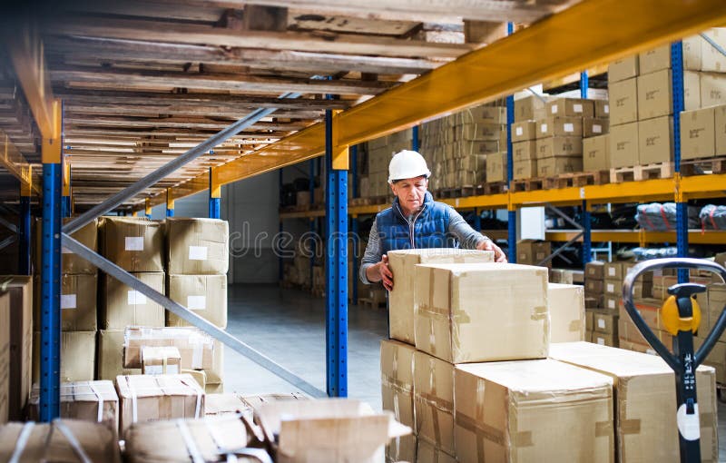 Senior Male Warehouse Worker Unloading Boxes from a Pallet Truck. Stock ...